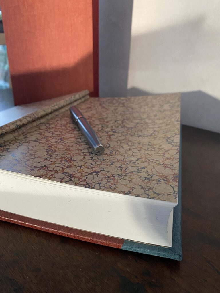 Large, Chunky plain paged book bound in terracotta and pale blue ...